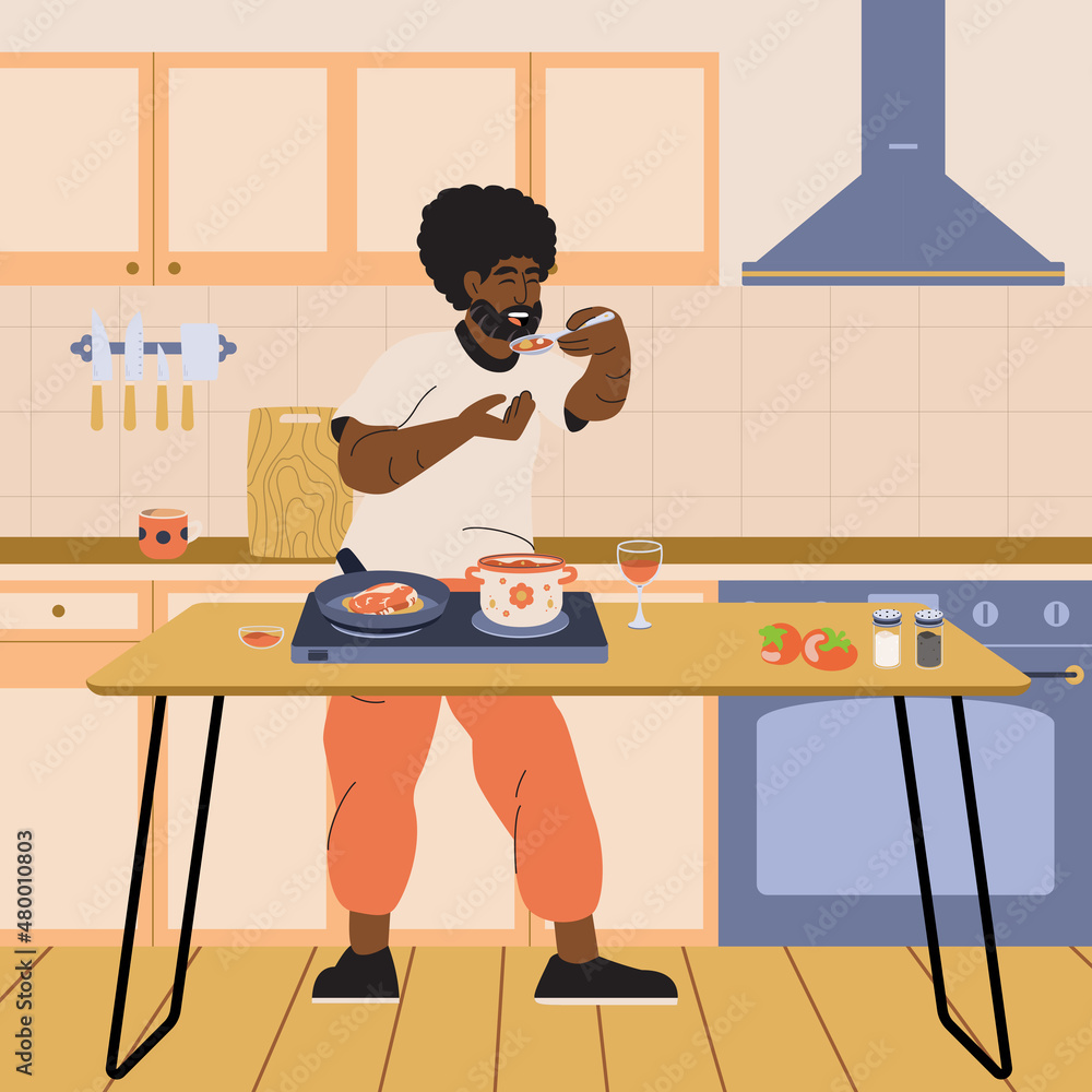 Man cooking in kitchen. Happy man tasting his cooking. Bearded chef ...