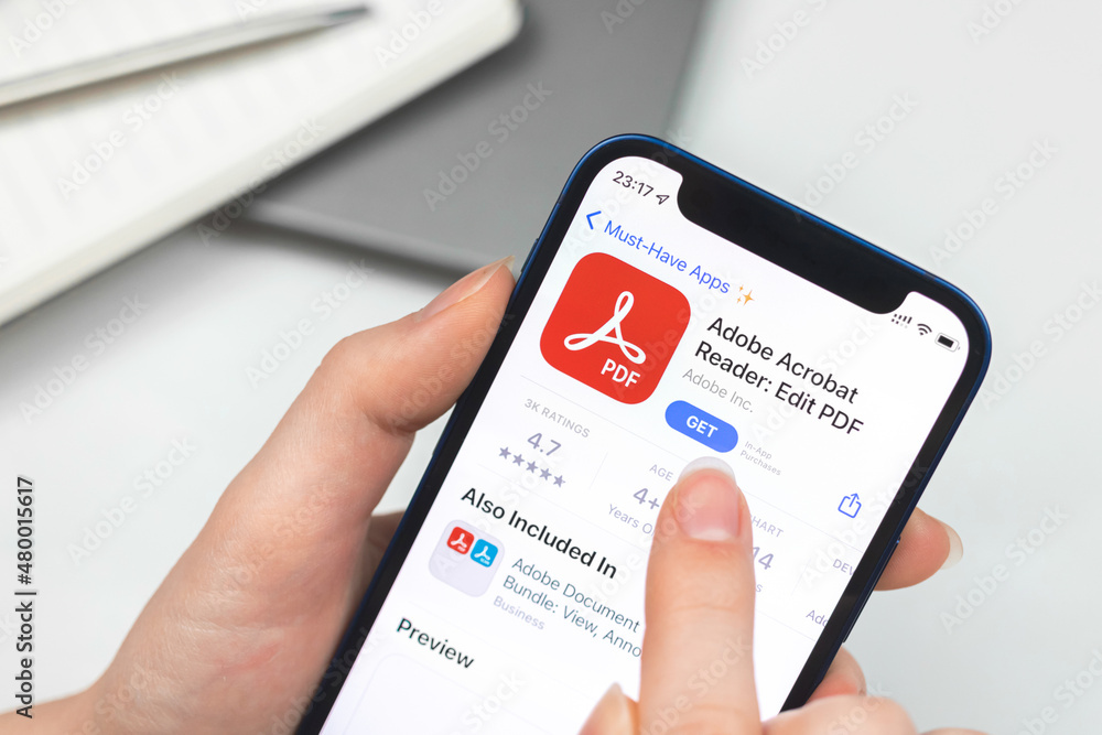 Adobe Acrobat Reader app icon close-up. Woman uses the application ...