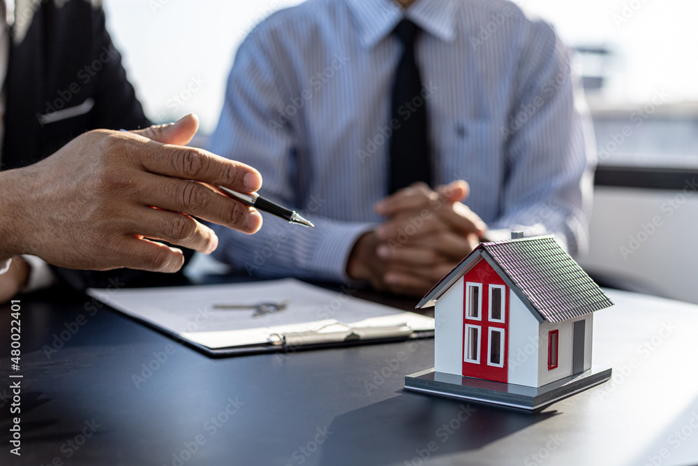 The property salesman on the project is pointing to a model of a small ...