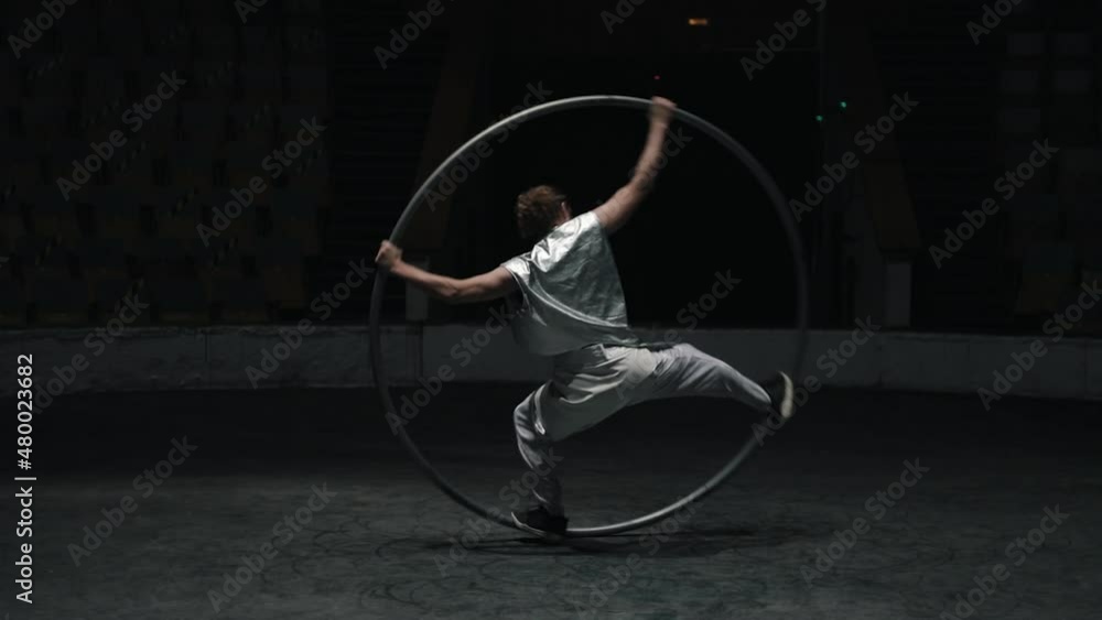 Circus artist Rotates on the wheel of Syrah in the arena. A large hoop ...