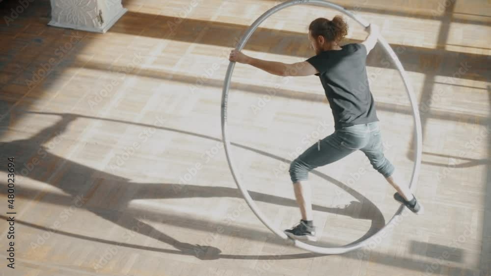 Circus performer Rotates on the Syrah wheel indoors on the parquet. The ...