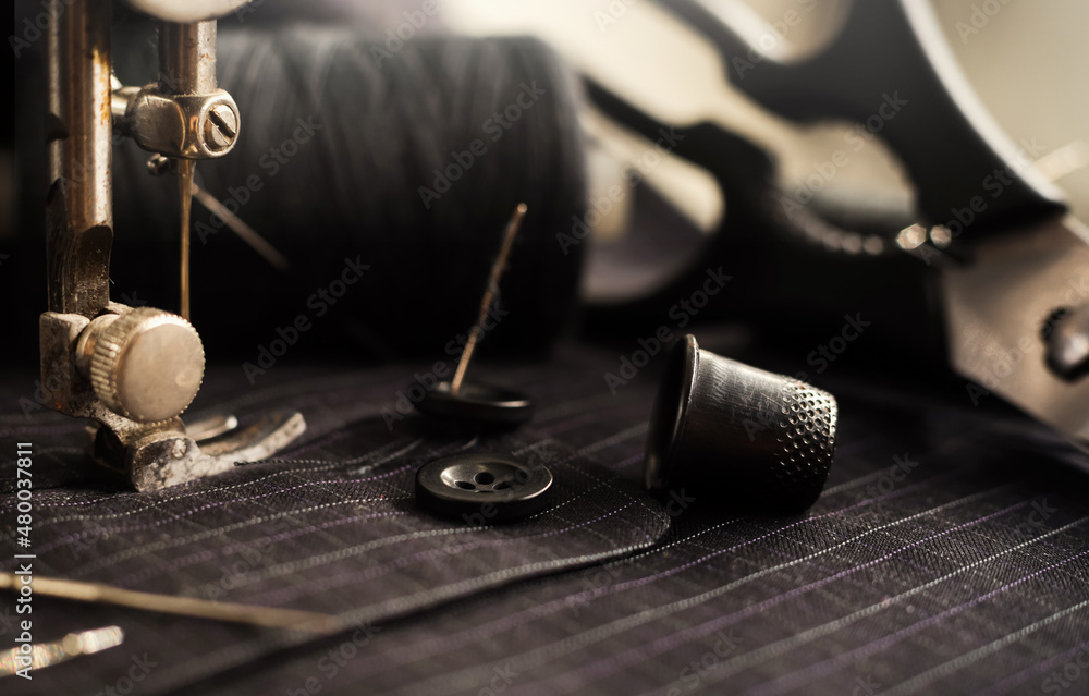 Old retro sewing machine, needle with thread, scissors and thimble ...