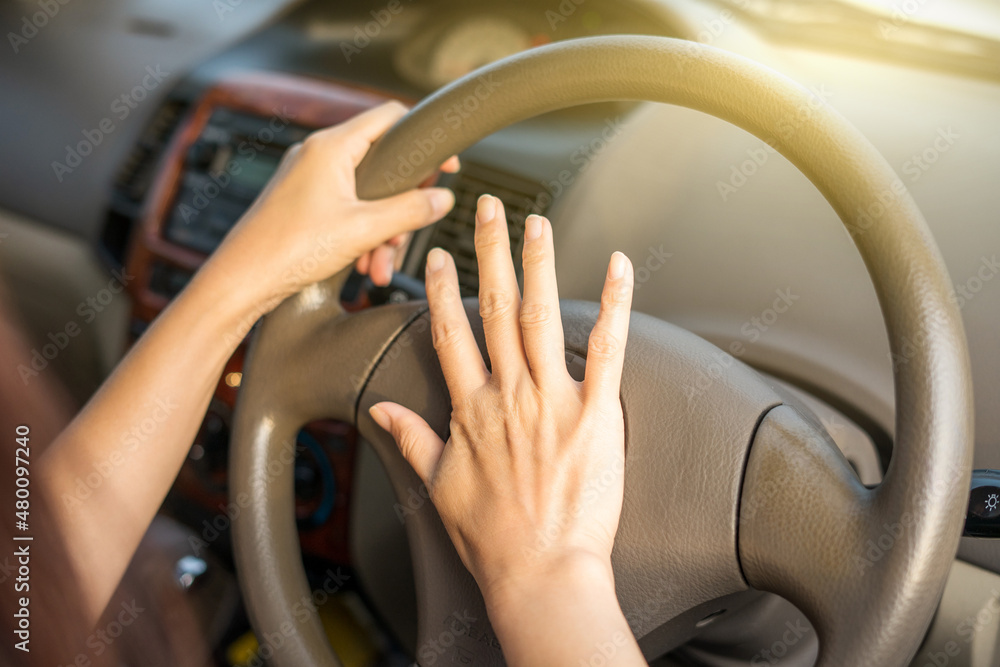 Hand female on the steering wheel of a car while driving the windshield ...