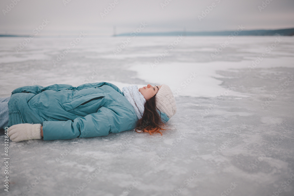 beautiful young girl lying on ice, frozen lake, girl lying in snow ...