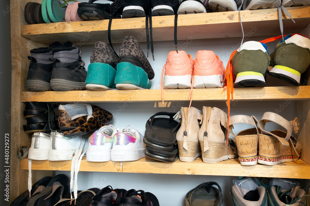 Collection of different shoes in shoe rack for storage, messy and needs ...