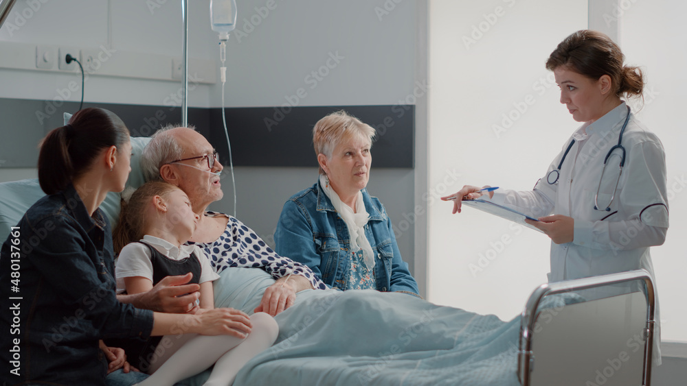 Doctor doing checkup visit with family visiting sick pensioner in ...