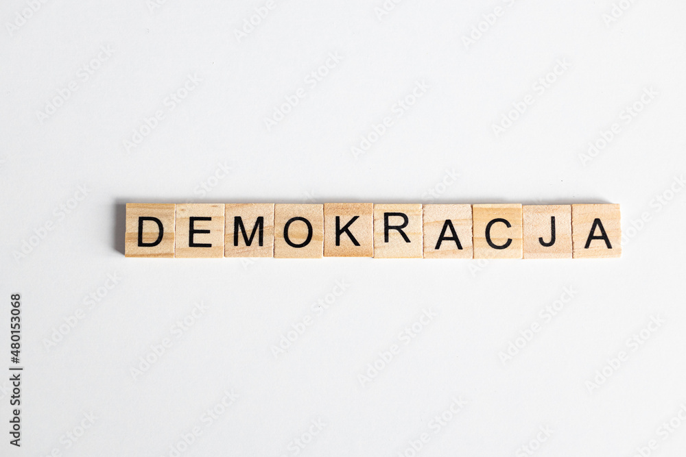 Demokracja w Polsce, słowa z drewnianych literek na jednolitym tle ...