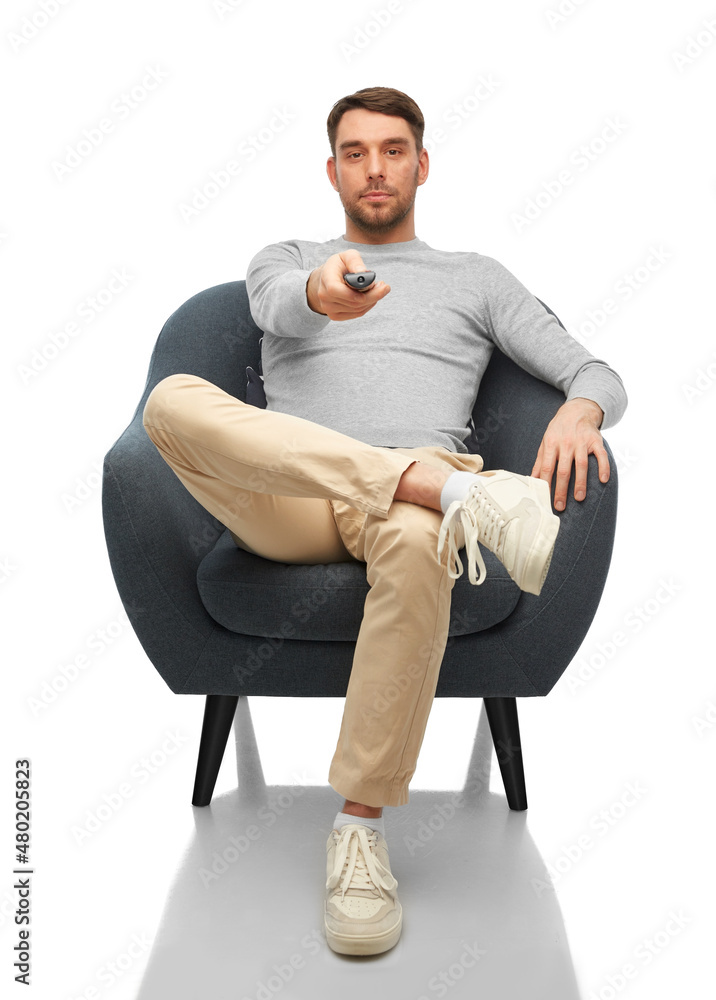 people and leisure concept - man with tv remote control sitting in ...