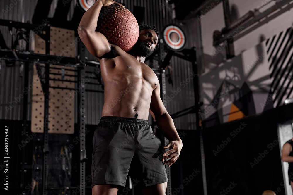 Strong man working out at indoors modern gym using medicine ball ...