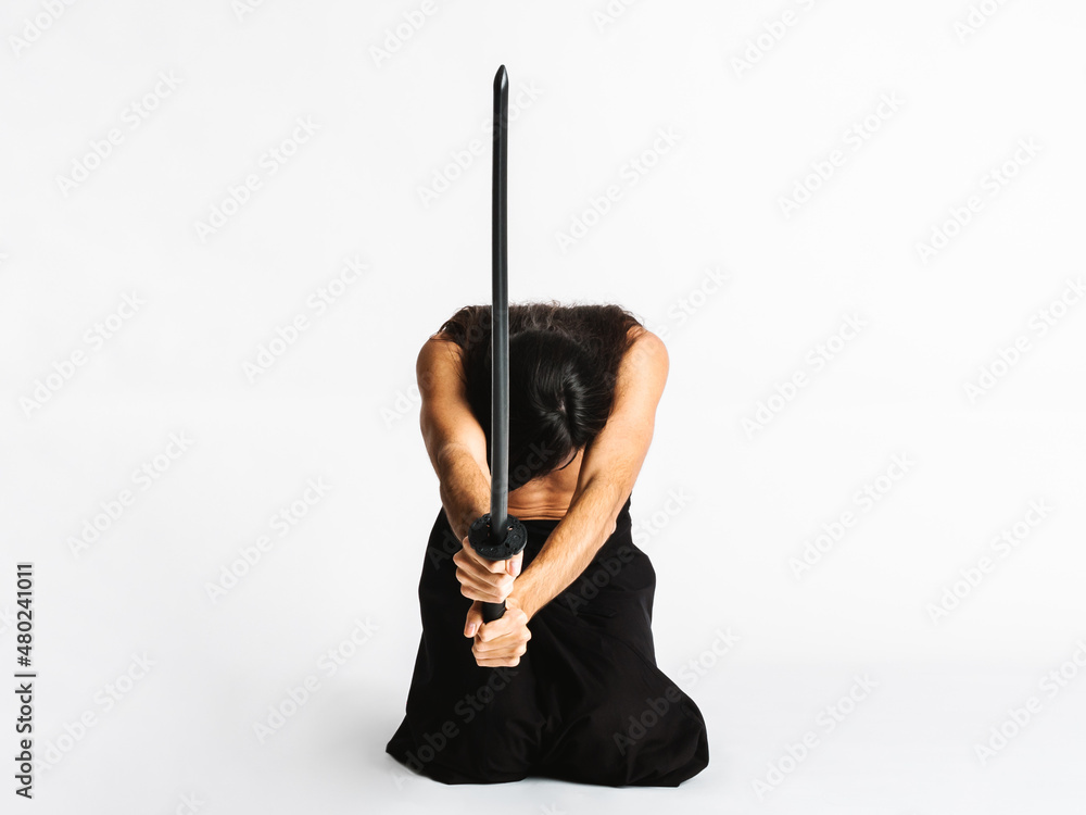 Long-haired, bearded man kneeling with head bowed with sword Stock ...
