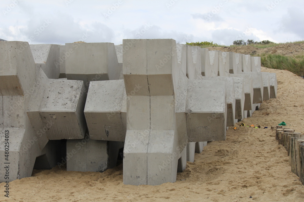 rows of big concrete blocs in x shape at the beach in cadzand at the ...