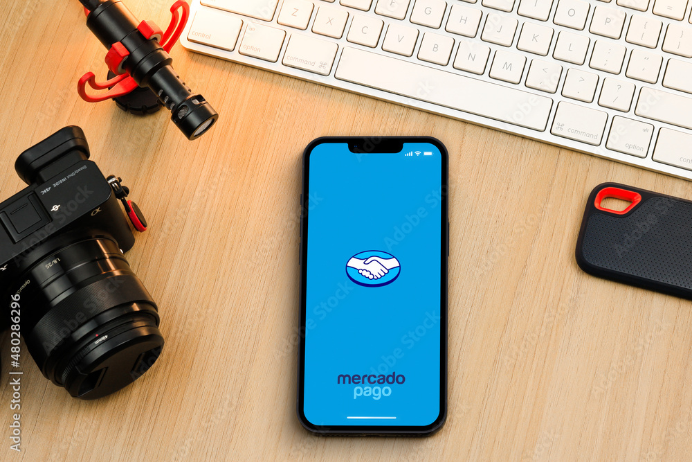 Mercado Pago app on smartphone iPhone 13 screen on wooden table ...