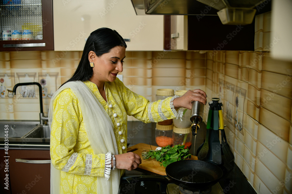 happy woman cooking in her kitchen indian pakistani model Stock Photo ...