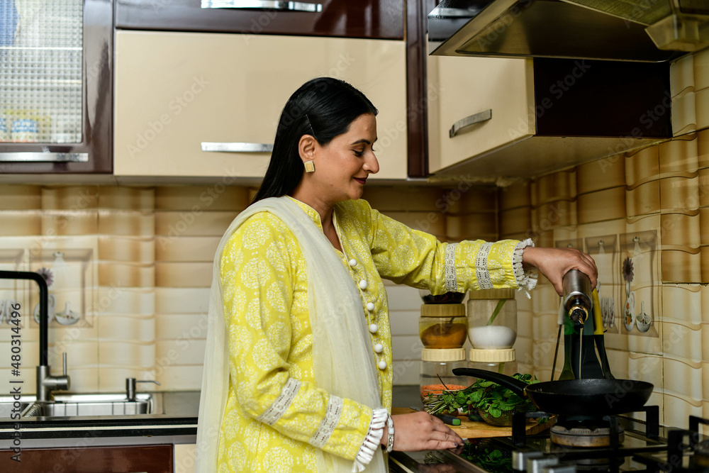 happy woman cooking in her kitchen indian pakistani model Stock Photo ...