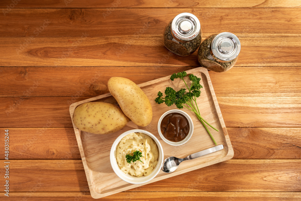Dish of mashed potatoes menu with brown gravy serve in a wooden tray ...