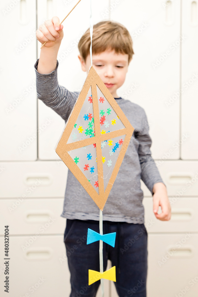 The child is creating a kite. The detail of the puzzle is a symbol of ...