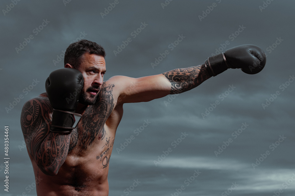 Portrait of tough male boxer posing in boxing gloves. Professional ...