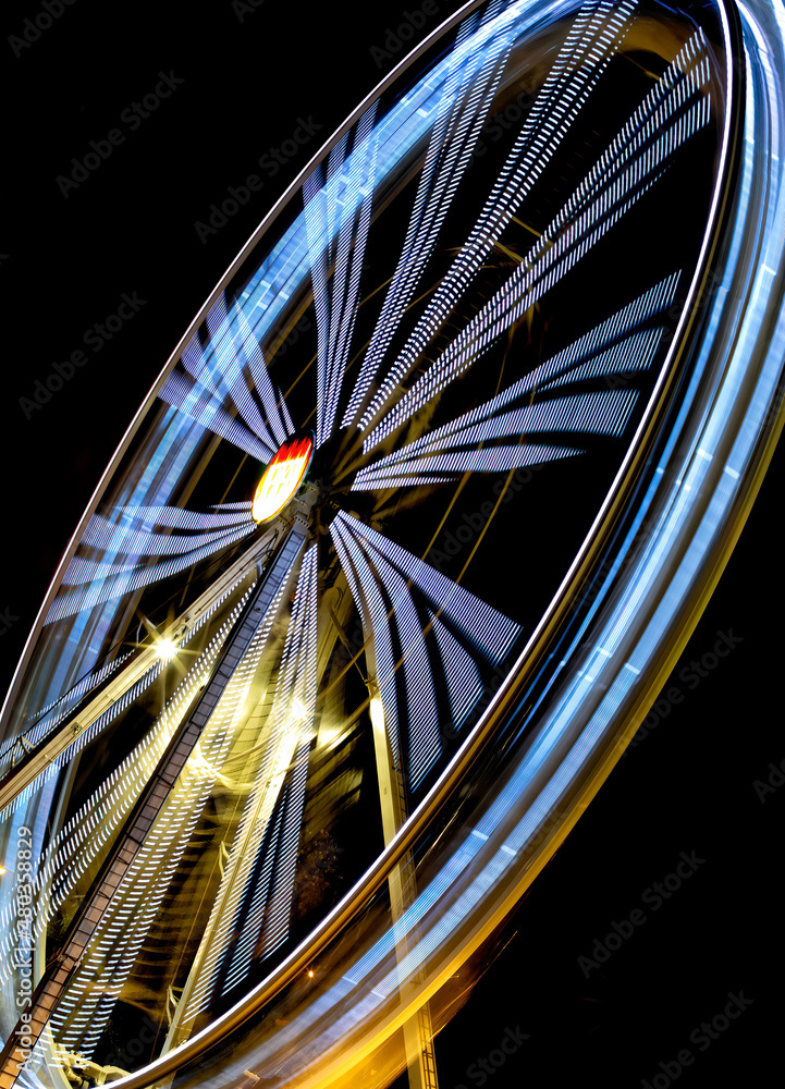 Defocused Ferris Wheel at amusement park at night. Blur abstract ...