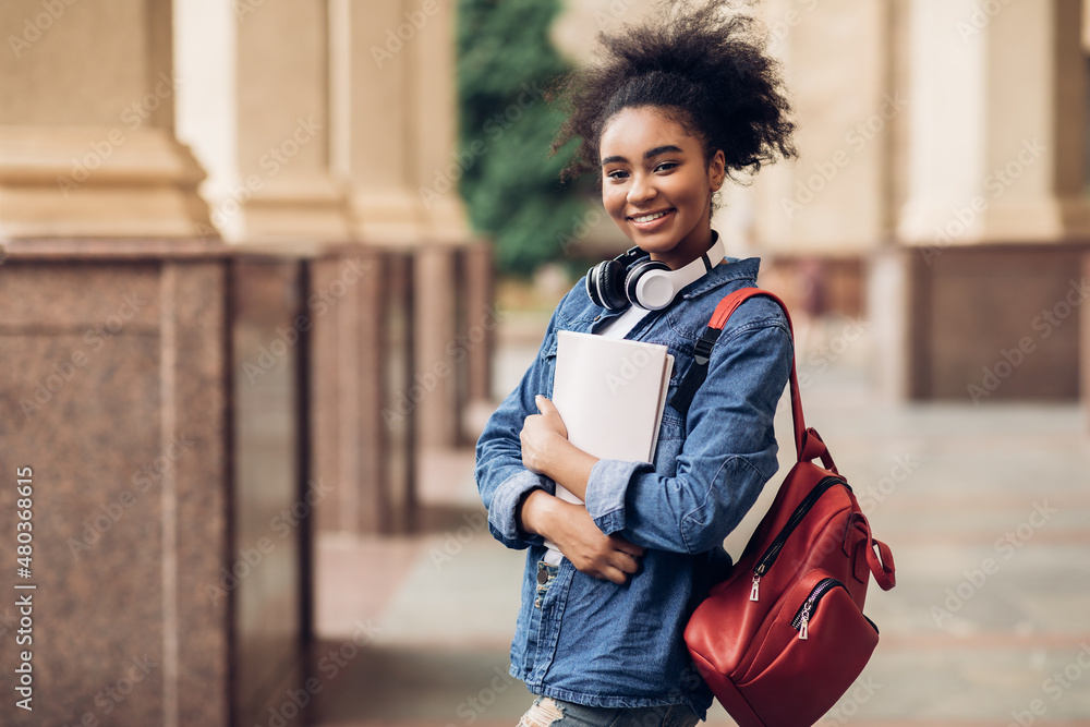 Foto de Cheerful Black Student Girl Hugging Books Posing Near College ...