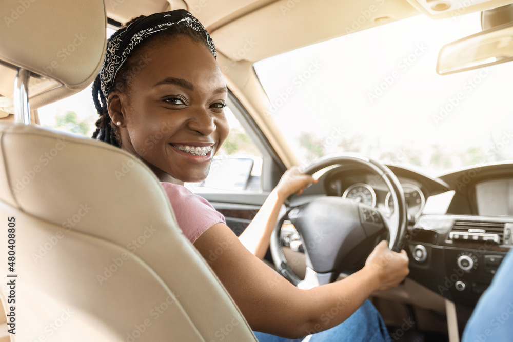 Confident black woman driving car, smiling at camera Stock Photo ...