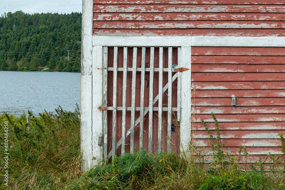 The corner of a two story vintage wooden barn with a single glass pane ...