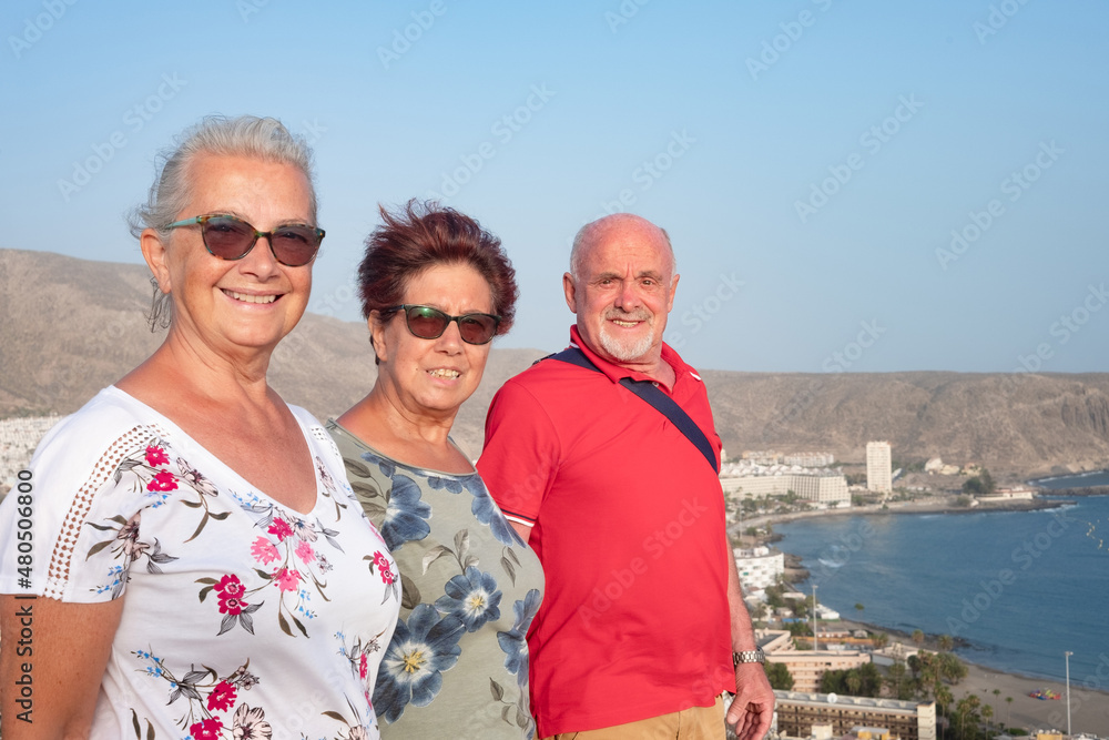 Happy adult senior friends enjoying scenery from the hill. A group of ...