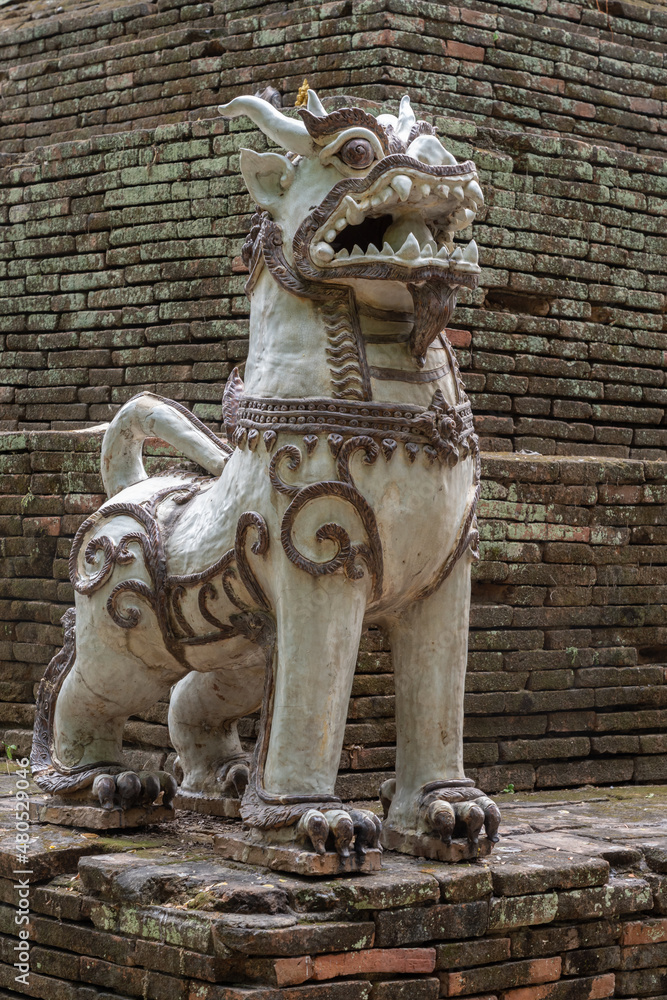 Beautiful ceramic chinthe or singha, a traditional lion guardian and protector at the base of ...