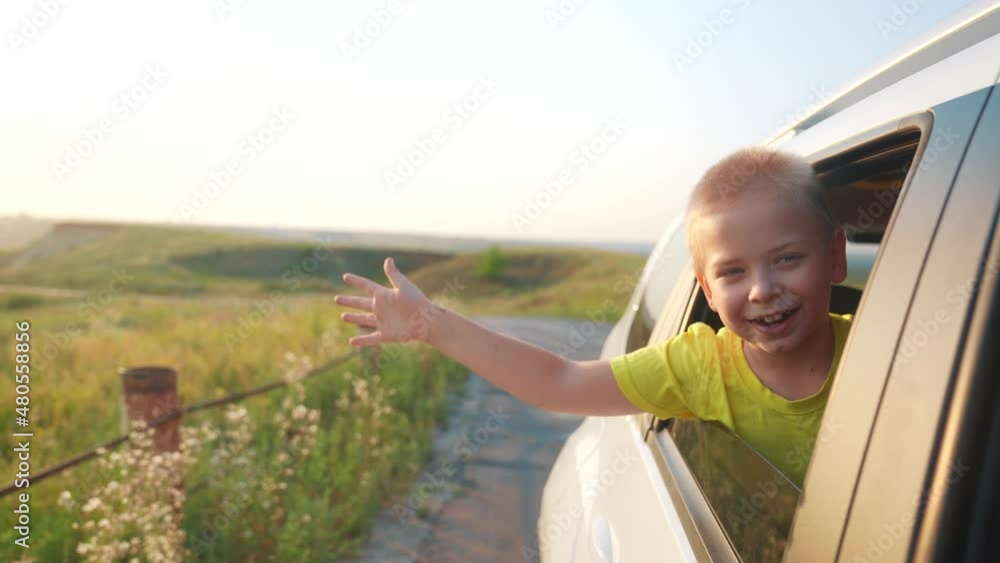 child boy waves from the car window. happy family a travel kid dream ...