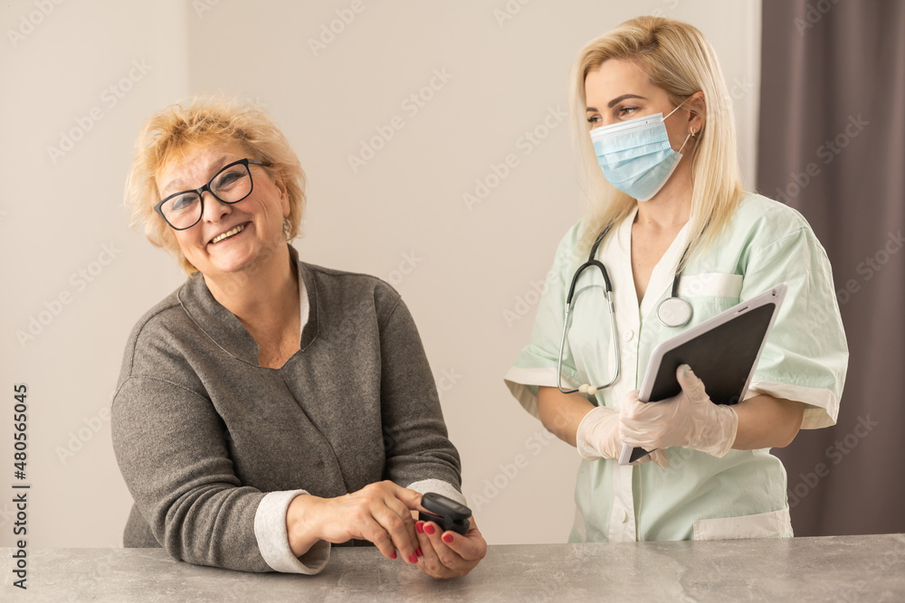 Hand of senior woman with an attached pulse oximeter on fingertip,old ...