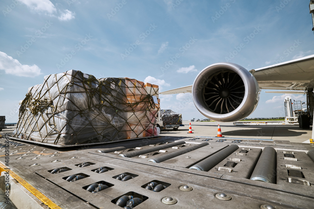 Preparation freight airplane before flight. Loading of cargo containers ...