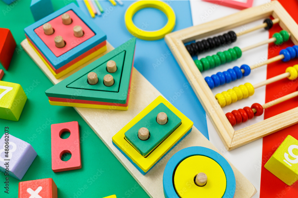 Multicolored wooden blocks on red background. Trendy puzzle toys ...
