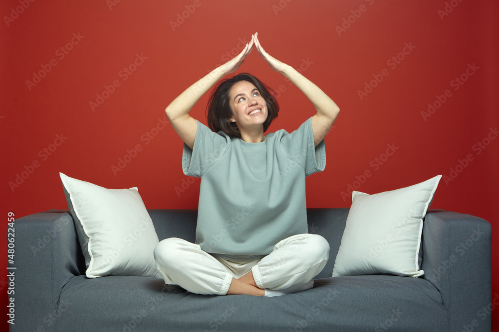 Smiling young girl make home roof gesture overhead, symbol of safety ...