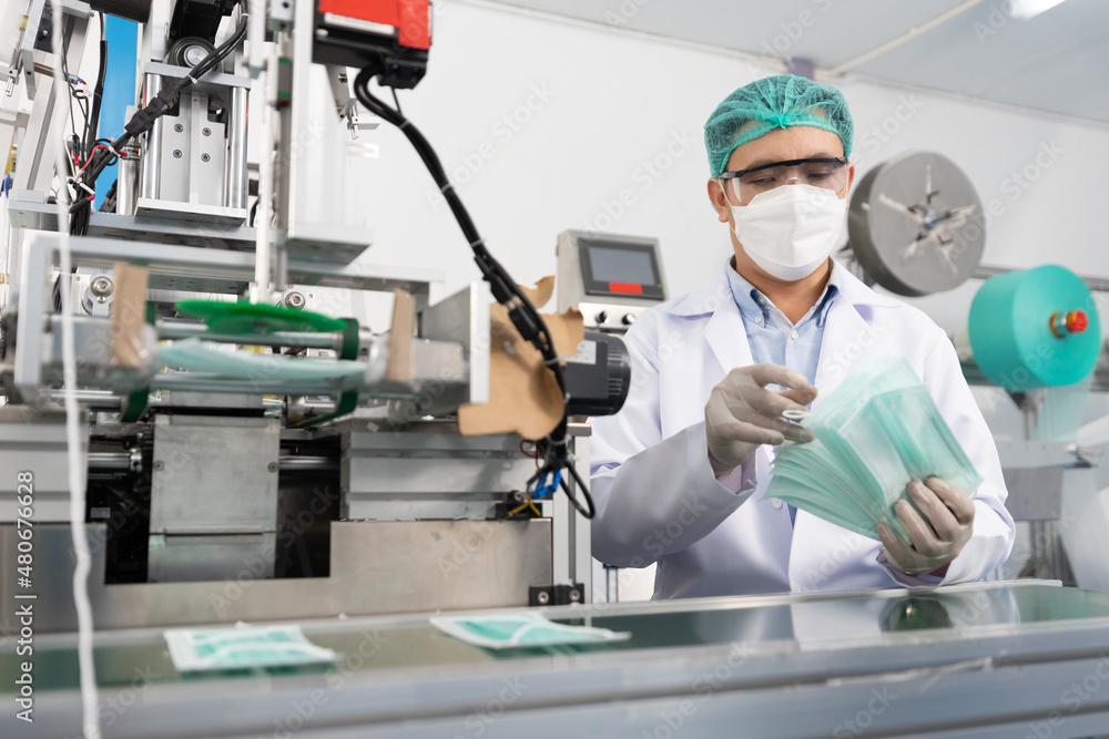 male factory worker are producing medical face masks, counting and ...