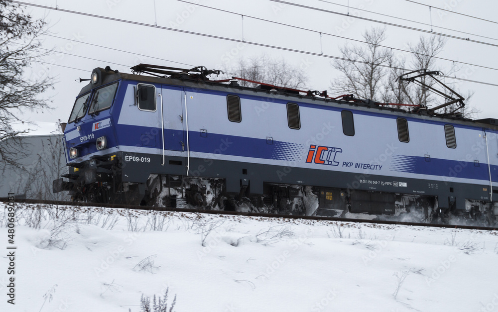 PKP class EP09 Polish electric locomotive with passenger cars. InterCity train going fast in a ...