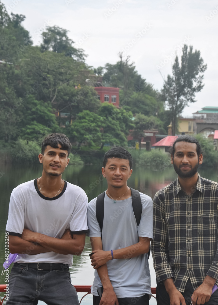 Front view of South Asian three male friends posing for photo beside ...