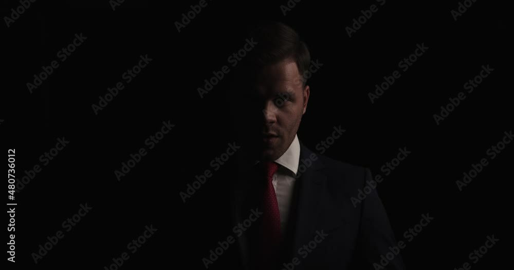 mysterious young man in suit moving in a back view position and walking ...