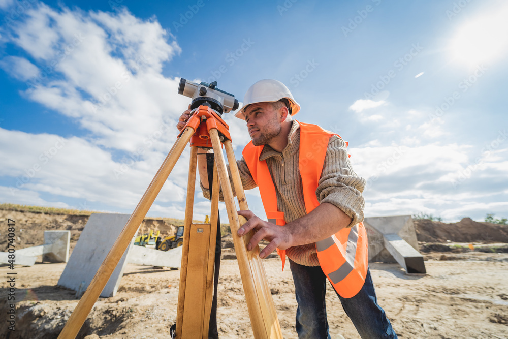 Poster Surveyor worker with theodolite equipment at construction site ...