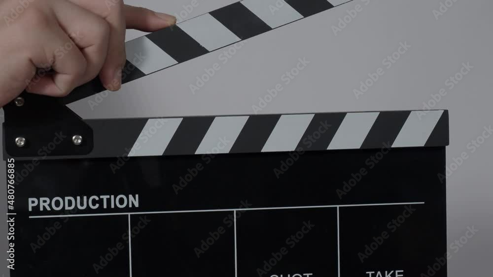 Movie slate or clapperboard hitting. Close up hand holding empty film ...
