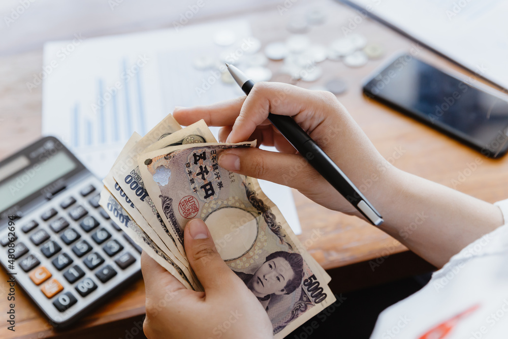Asian girl counting Japanese Yen calculator for personal accounting ...
