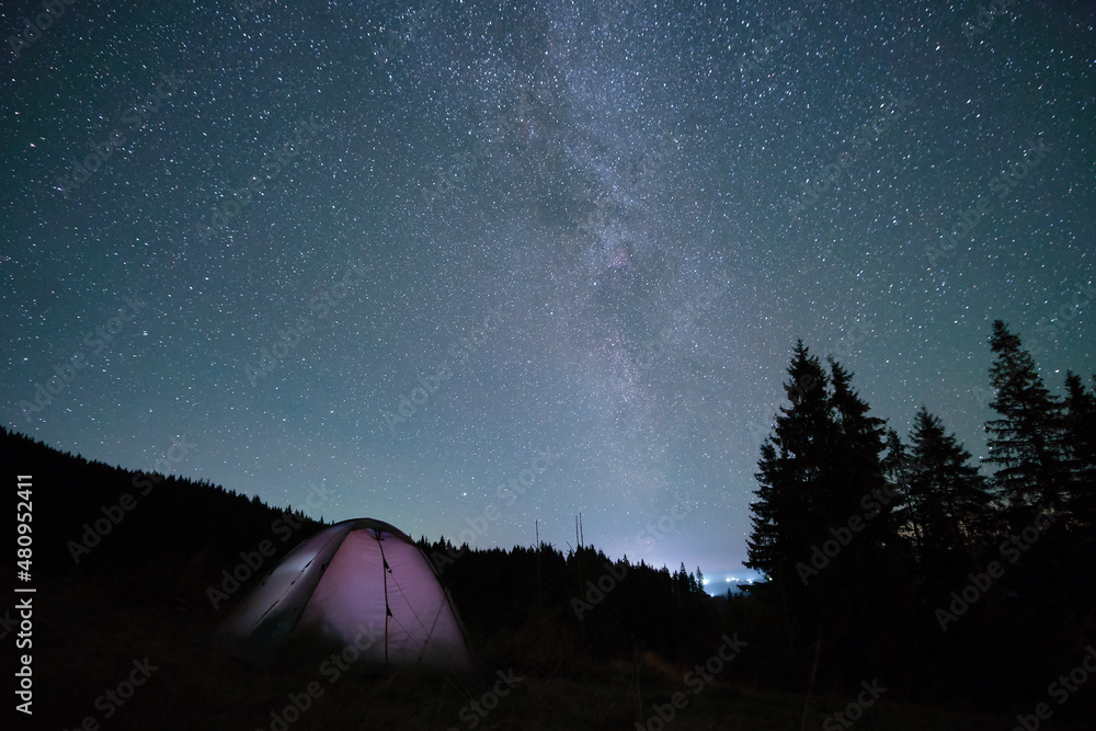 Bright illuminated tourist tent glowing on camping site in dark ...