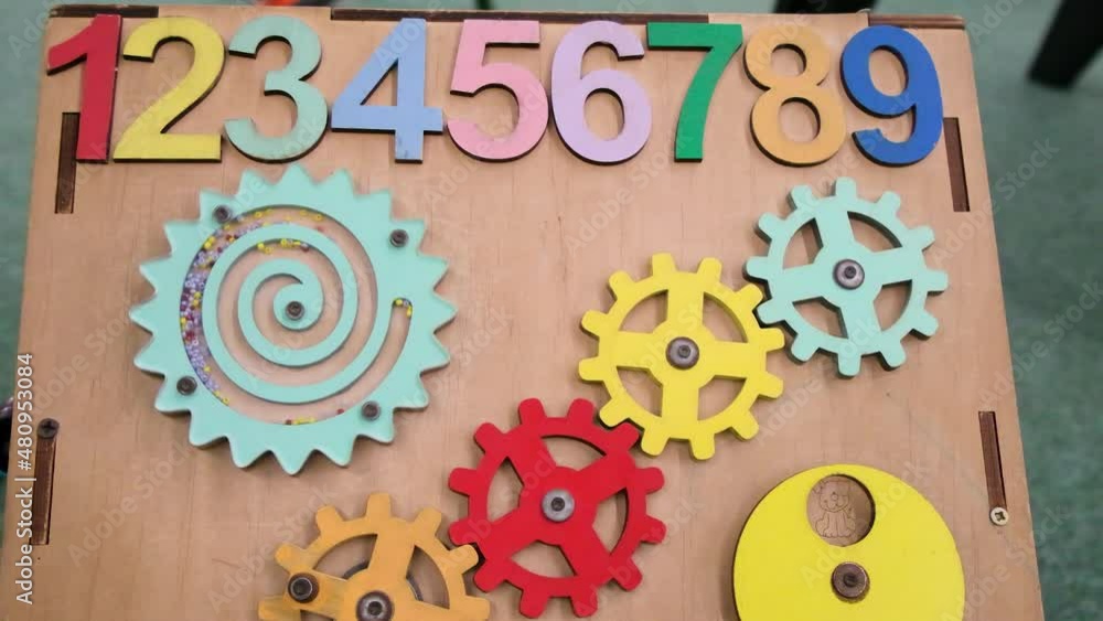 Busy Board for children, wooden board with numbers, gears are spinning ...