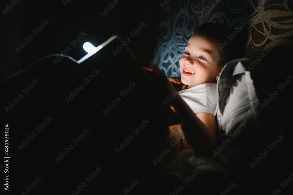 Child reading book in bed. Kids read at night. Little boy with fairy ...