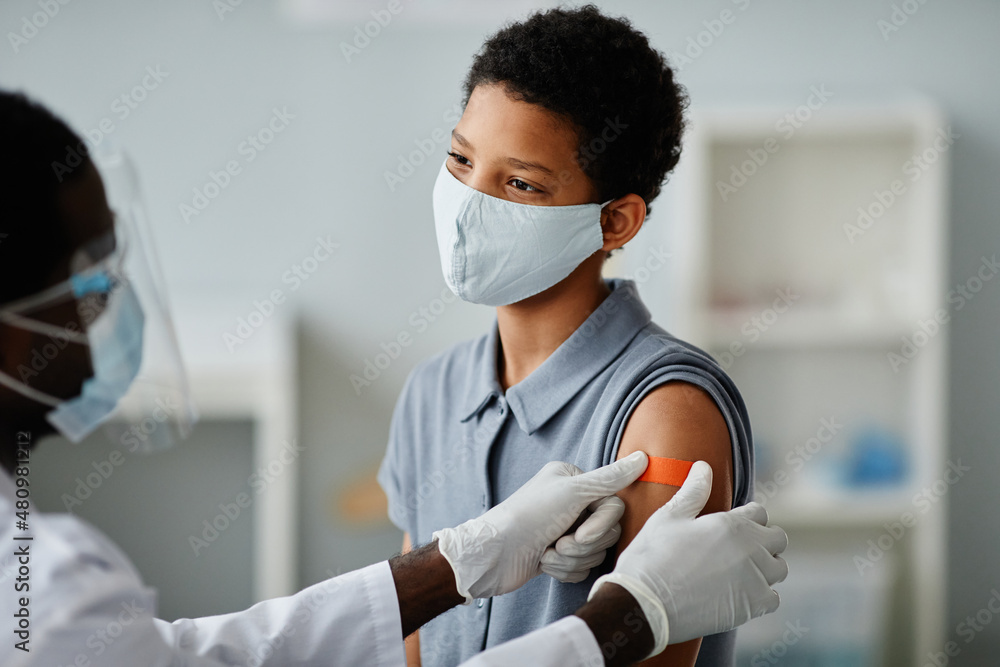 Portrait of brave African-American girl getting vaccinated in child ...