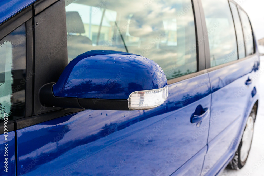 Details and parts of the body close-up. Side mirror of a blue car ...