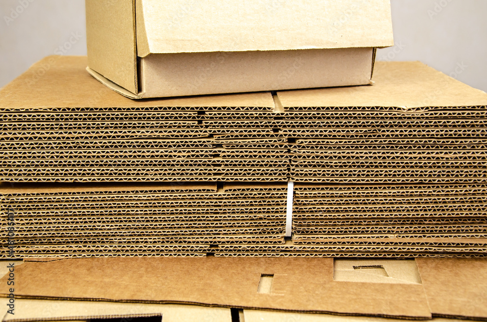 box ready for product packaging and a stack of folded corrugated ...