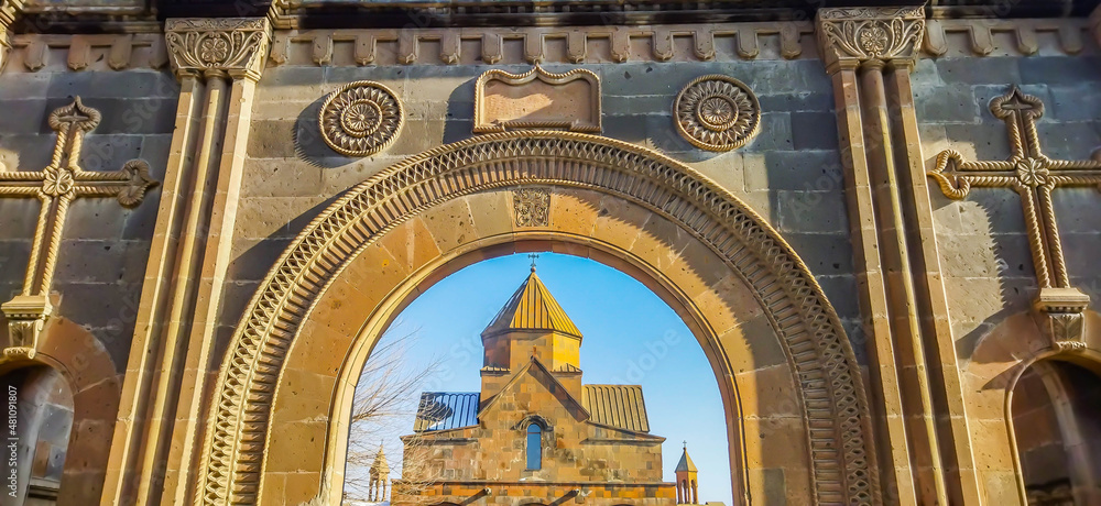 Arch and church. Stone wall with crosses. The monastery is visible ...