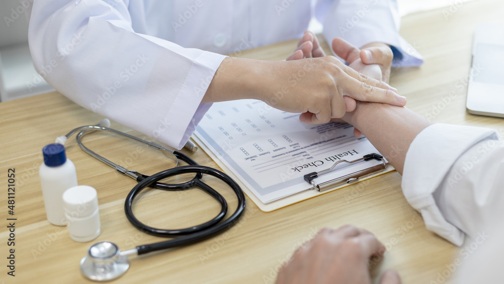 Medical professional measures the pulse of a male patient's wrist to ...