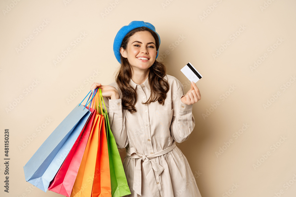 Portrat of trendy feminine girl posing with shopping bags from store ...