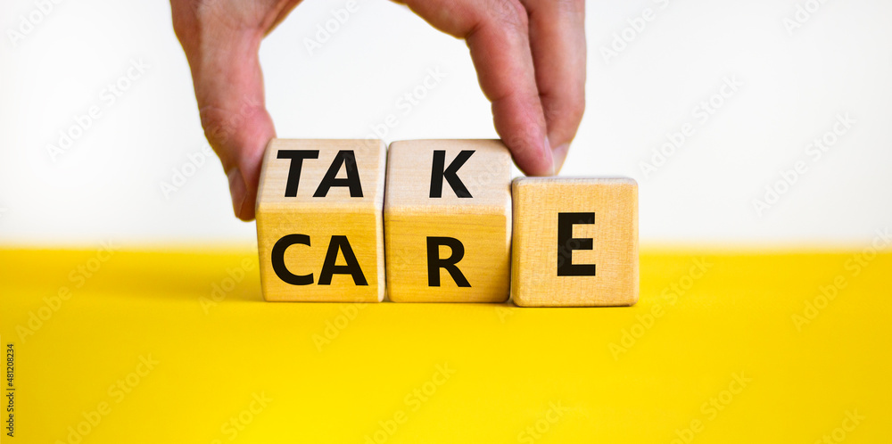 Take care symbol. Businessman turns wooden cubes and changes the word ...