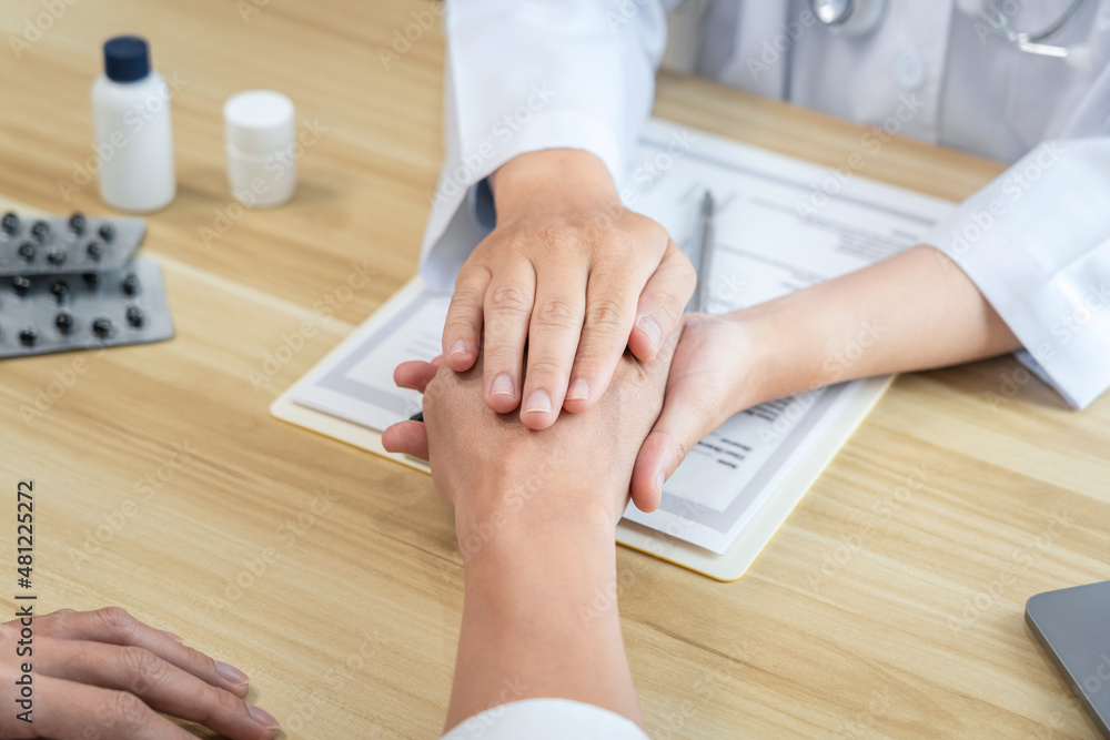 Doctor touching patient hands for encouragement and empathy on the ...